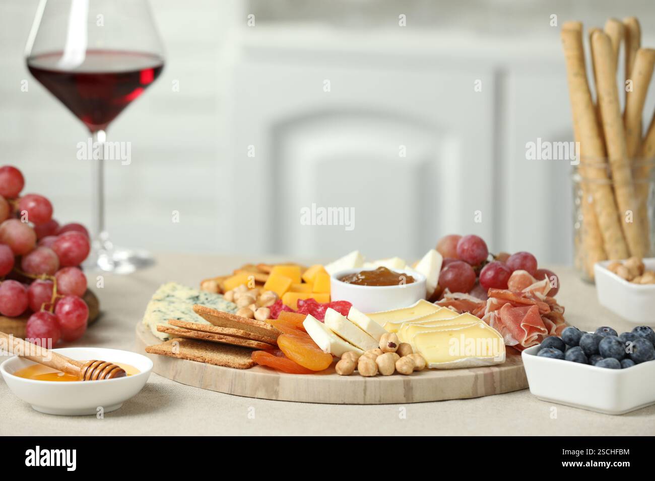 Different types of cut cheese and other snacks on light textured table ...