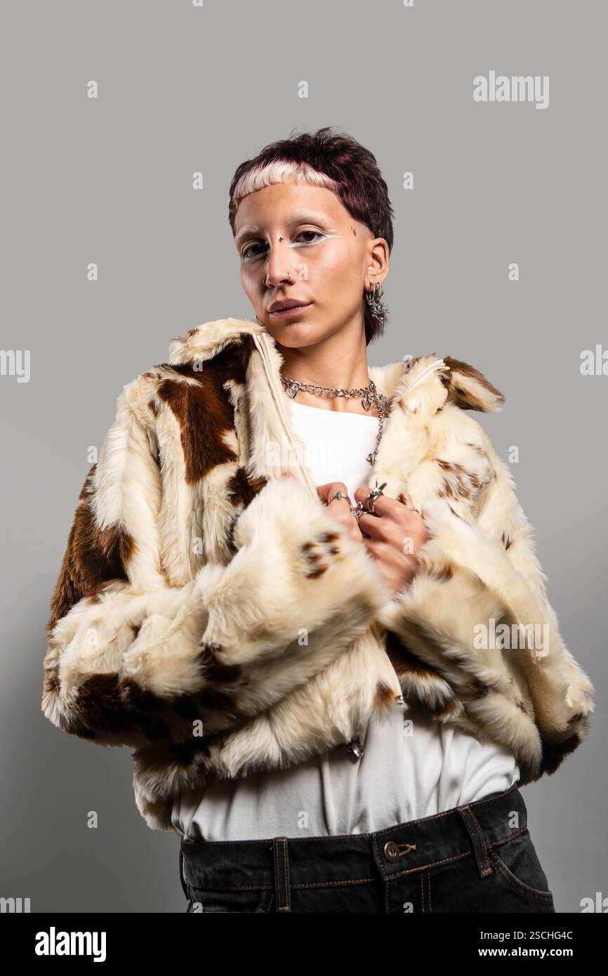 A woman with distinctive makeup and jewelry poses confidently in a ...