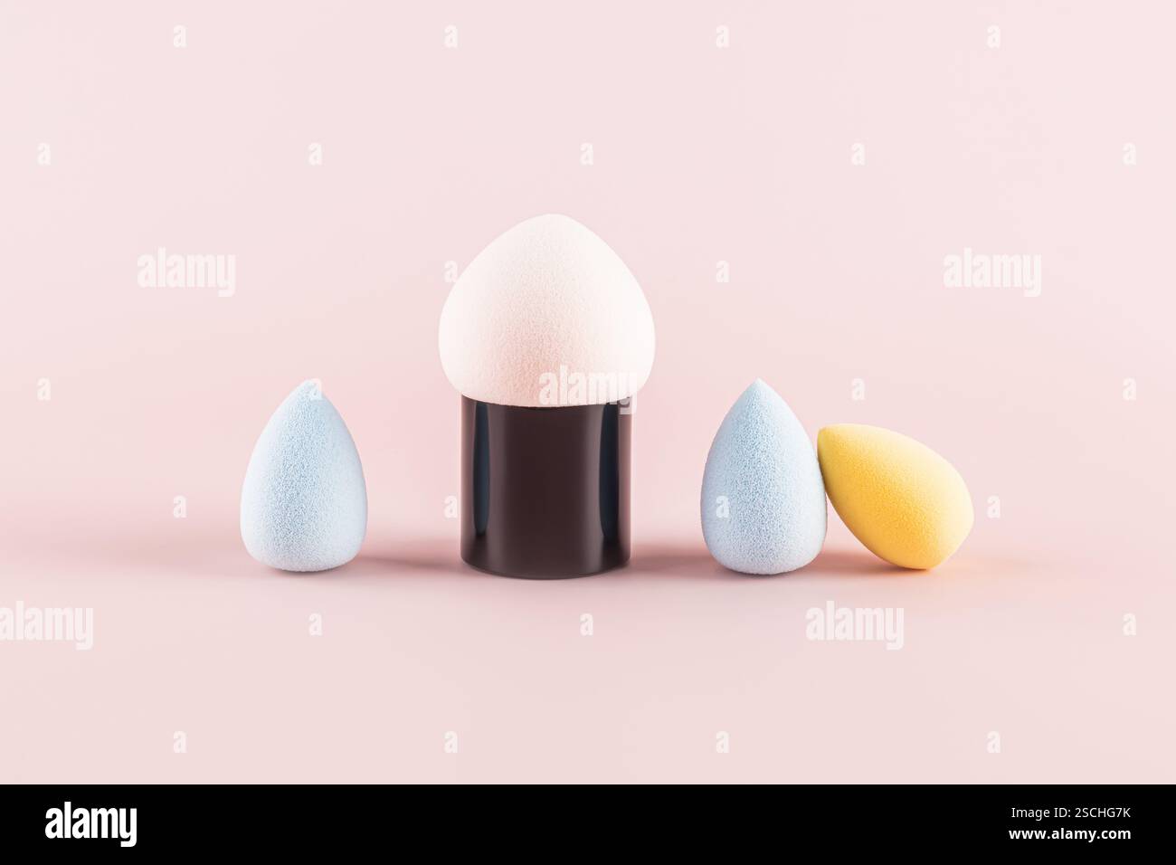 Makeup sponges, also known as beauty blenders, displayed on a soft pink ...