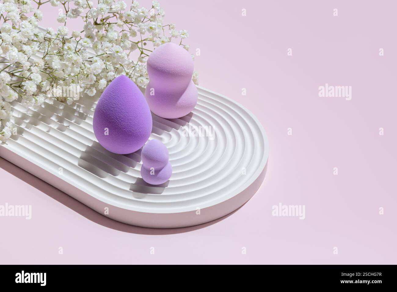 Various sizes of purple beauty blender makeup sponges arranged ...