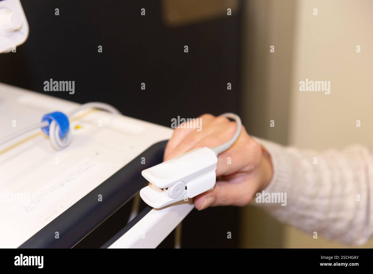 A mature woman is undergoing a pulse oximetry test in a hospital ...