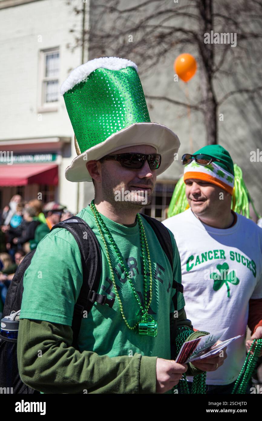 St. Patrick's Day parade. Men in green hats & shirts, wearing beads ...