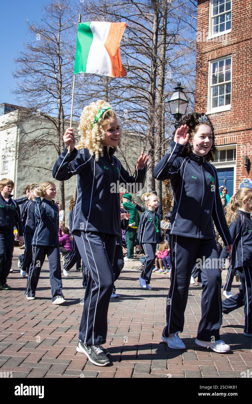 Irish dancers (Evie, Caili) in St. Patrick's Day parade, carrying flag ...