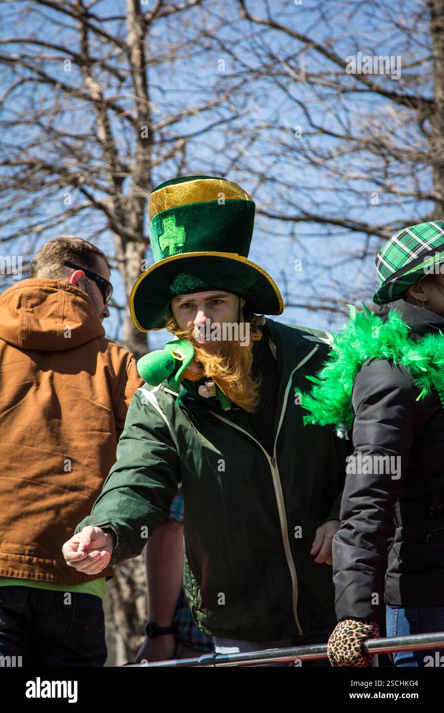 St. Patrick's Day parade. Man in leprechaun hat handing out treats ...