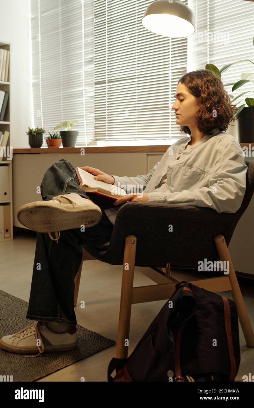 Teen Boy Reading Book at School Library Studying Stock Photo - Alamy