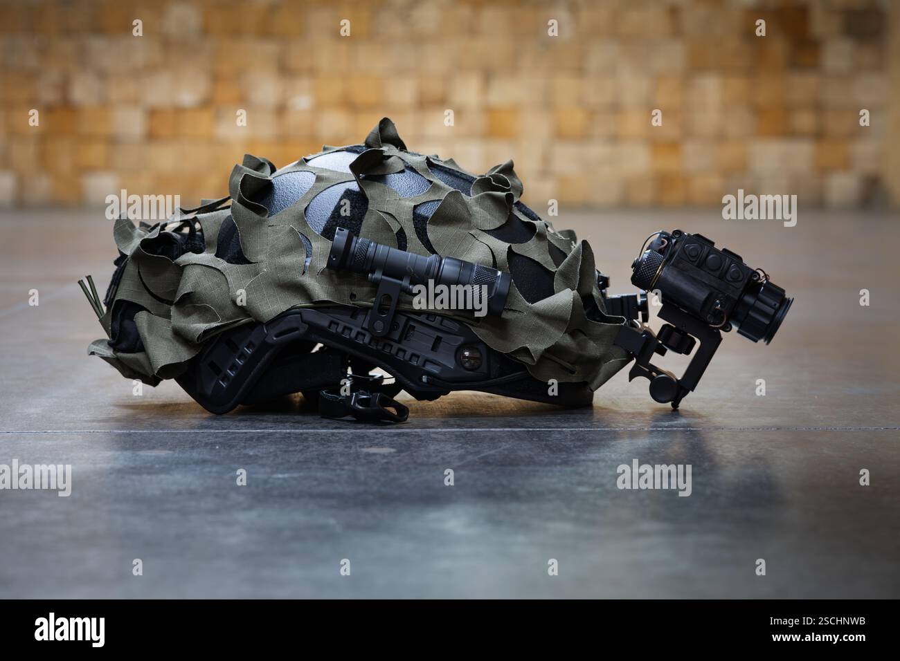 A tactical helmet with a thermal imaging monocular and a flashlight ...