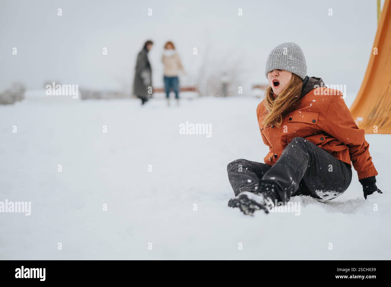 Young person sliding on snow during a fun winter activity Stock Photo ...
