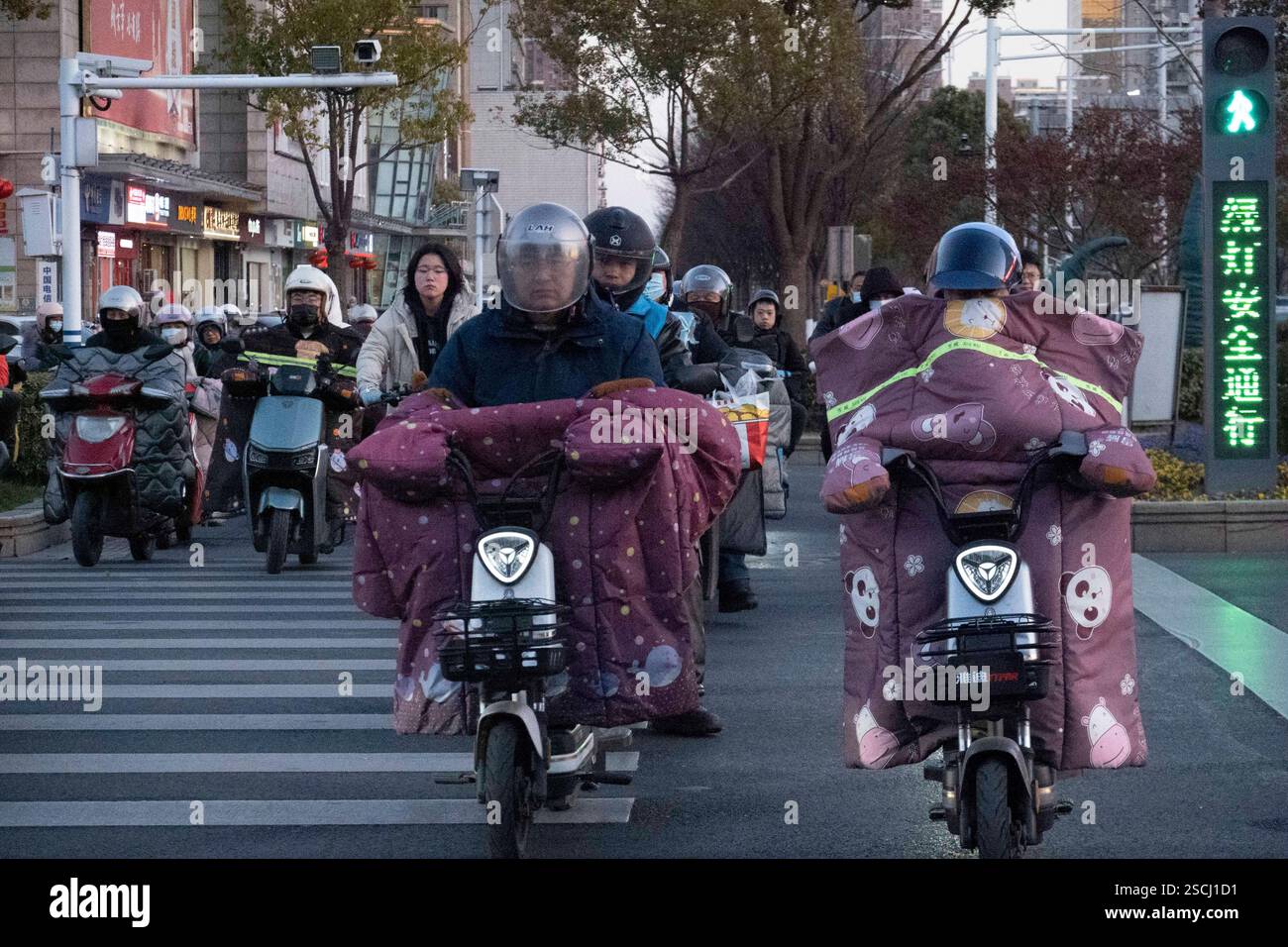HAIAN, CHINA - FEBRUARY 7, 2025 - Citizens riding with thick clothes in ...