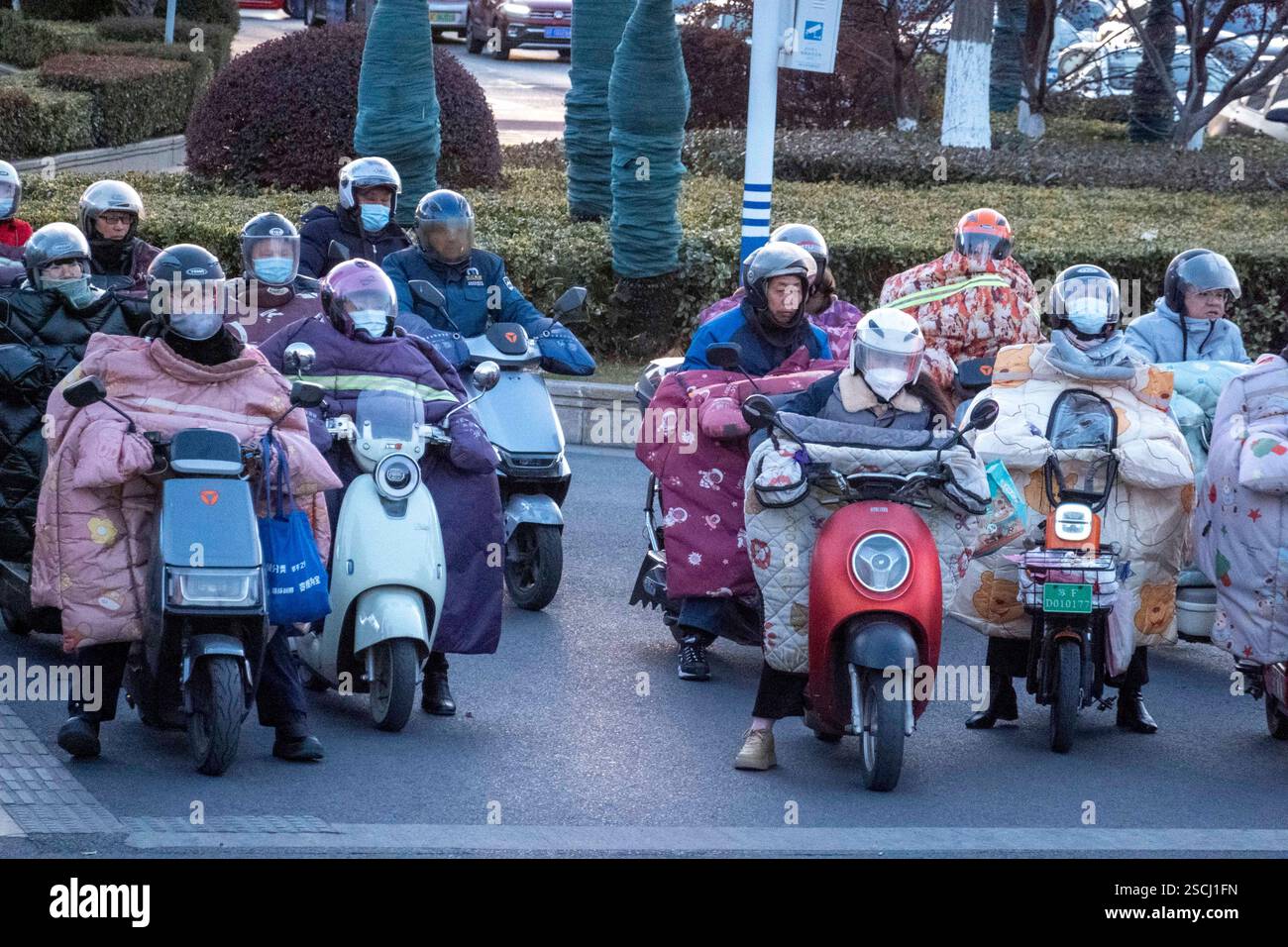 HAIAN, CHINA - FEBRUARY 7, 2025 - Citizens riding with thick clothes in ...