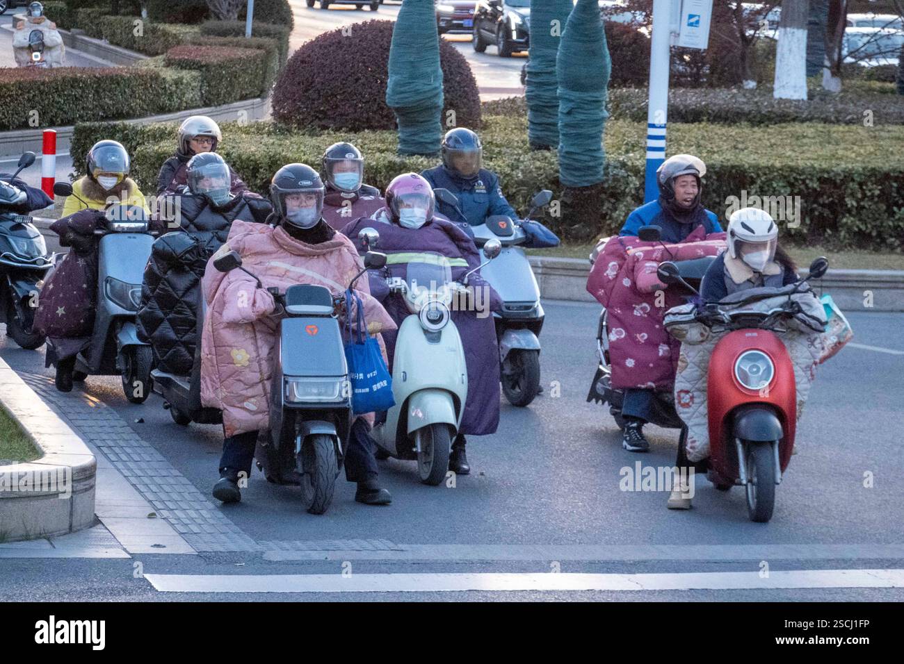 HAIAN, CHINA - FEBRUARY 7, 2025 - Citizens riding with thick clothes in ...