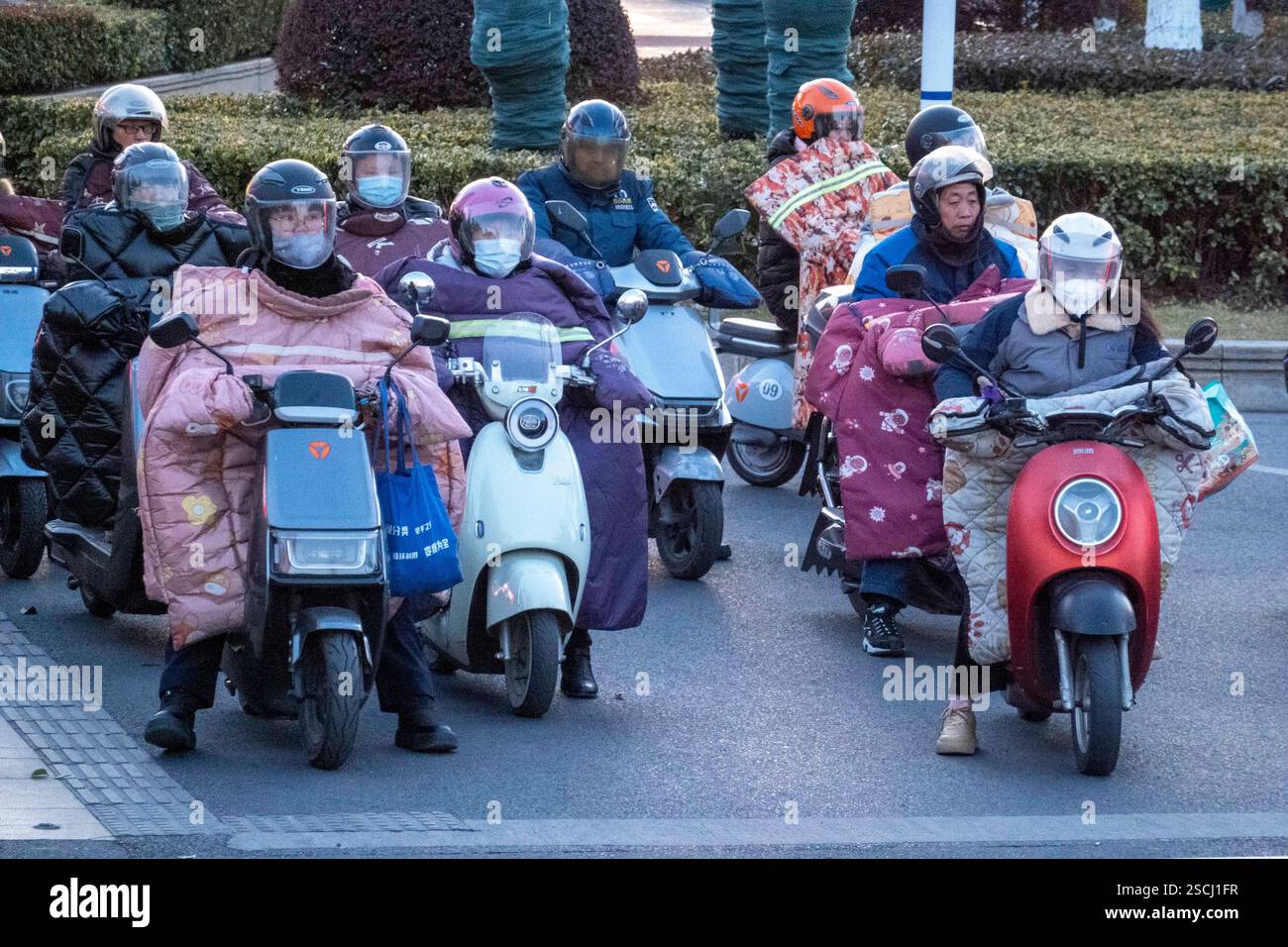 HAIAN, CHINA - FEBRUARY 7, 2025 - Citizens riding with thick clothes in ...