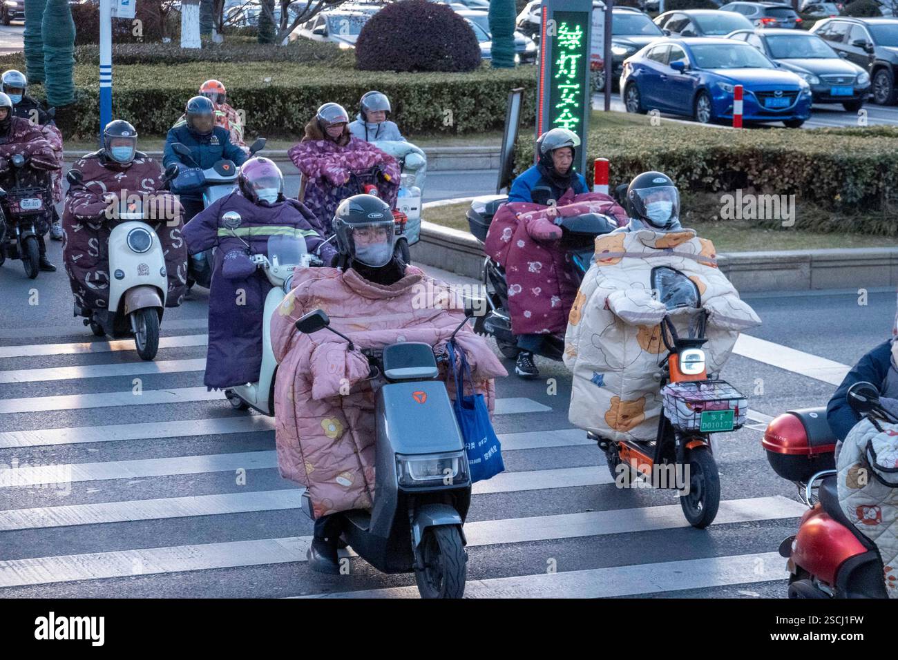 HAIAN, CHINA - FEBRUARY 7, 2025 - Citizens riding with thick clothes in ...