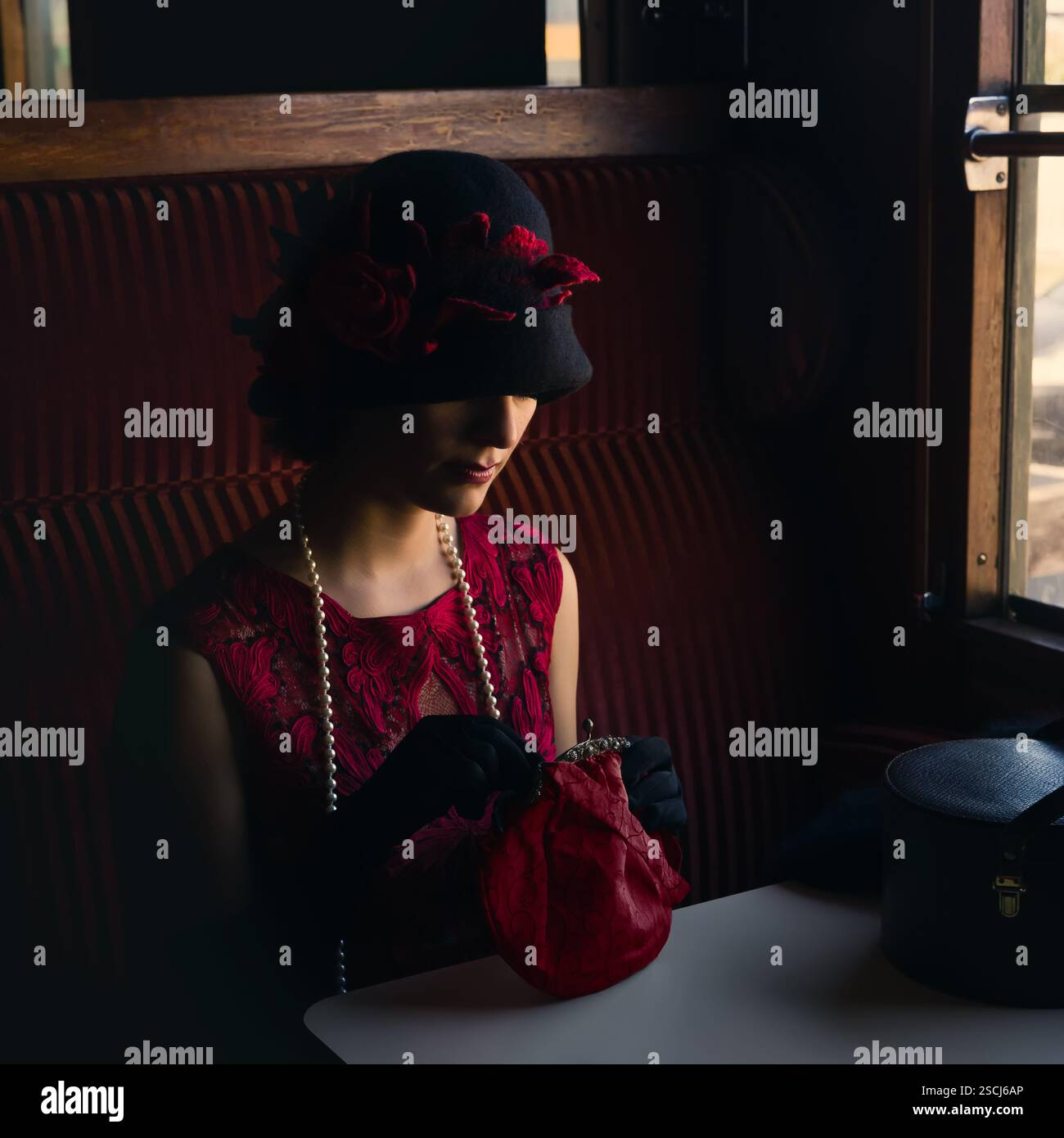 Attractive 1920s woman in red flapper dress and cloche hat posing in ...