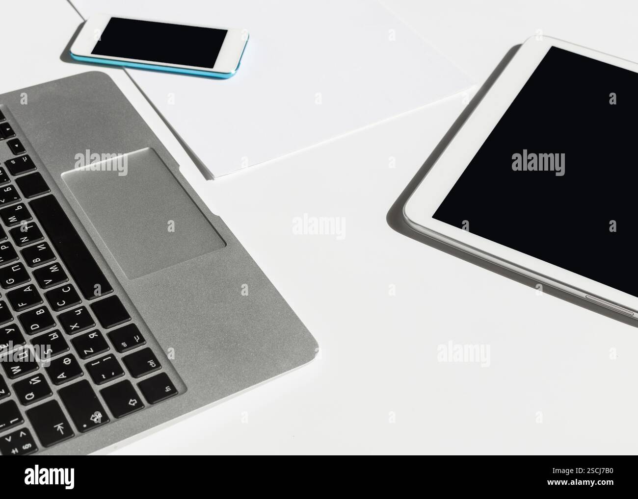 Workspace setup featuring laptop, tablet, and smartphone on a ...