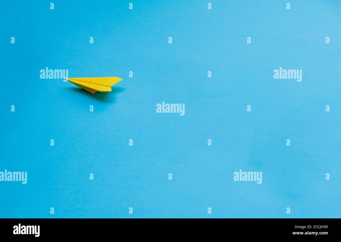Yellow paper airplane on blue background Stock Photo - Alamy