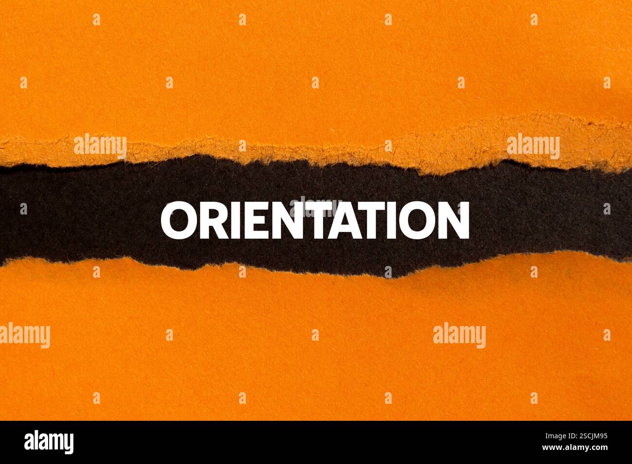 Orientation message written on ripped torn orange paper on black ...