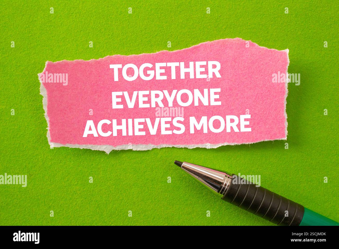 Together everyone achieves more message written on ripped torn pink ...