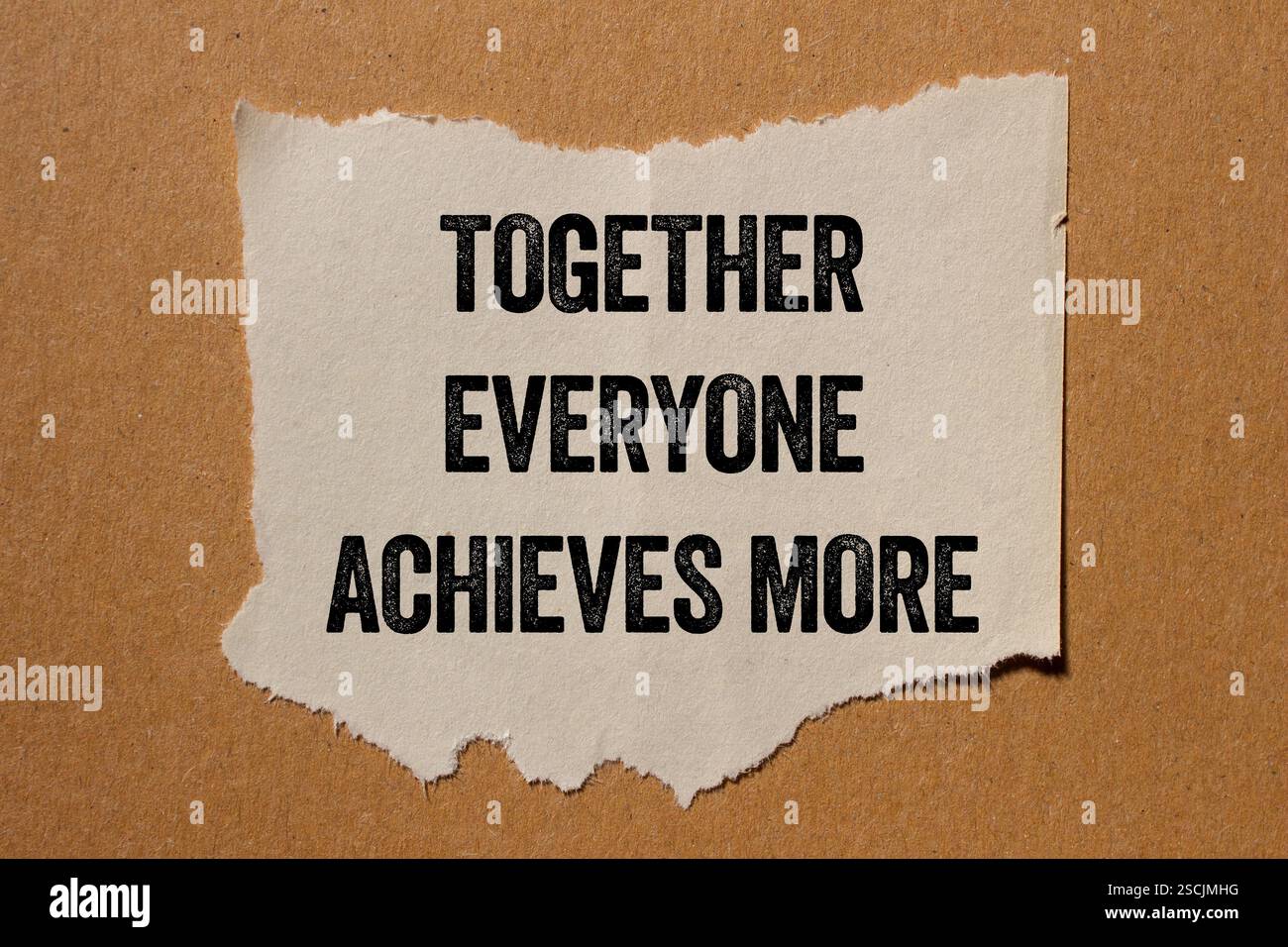 Together everyone achieves more message written on ripped torn paper ...