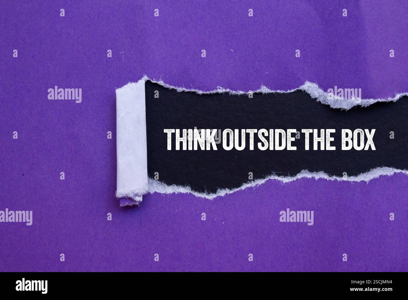 Think outside the box message written on ripped torn purple paper on ...