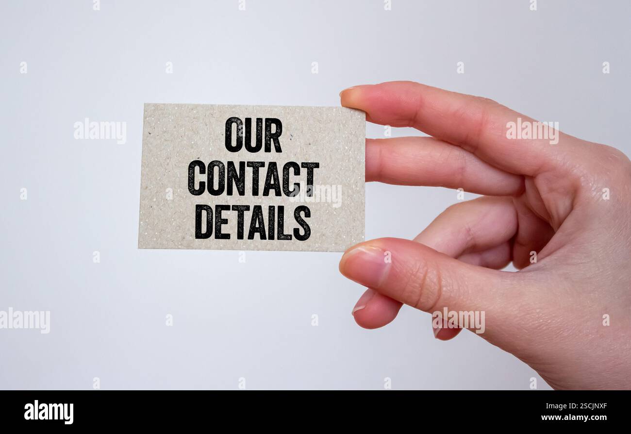 Our contact details message written on a card in hand. Conceptual our ...