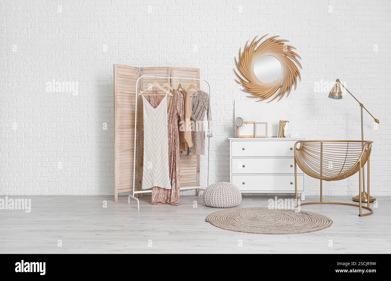 Interior of dressing room with golden mirror, clothes rack and commode ...