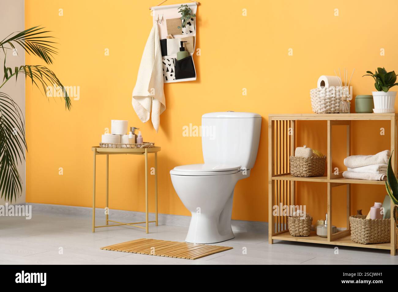 Interior of restroom with white toilet bowl, coffee table and shelving ...