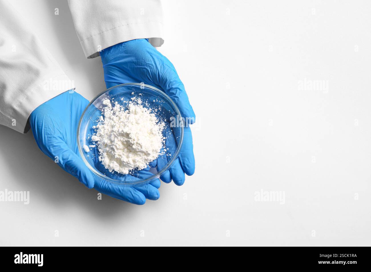 Female scientist's hands holding Petri dish with powder sample on white ...