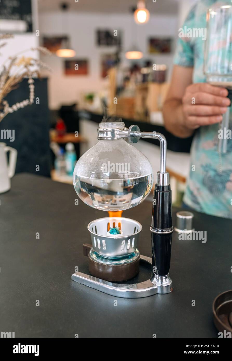 Japanese coffee maker boiling water while barista wait to put siphon ...