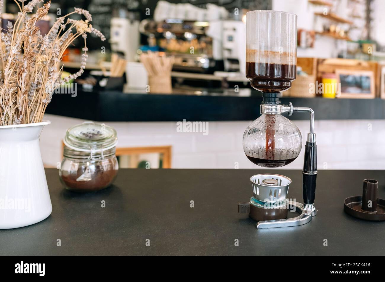 Brewing coffee with Japanese siphon maker in a empty modern cafe ...