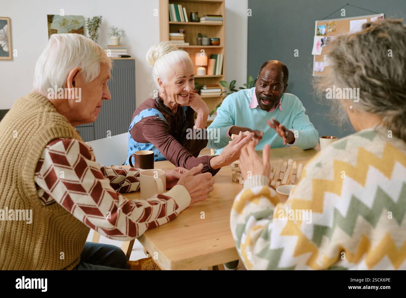 Over shoulder view of biracial companions sitting at table screaming ...