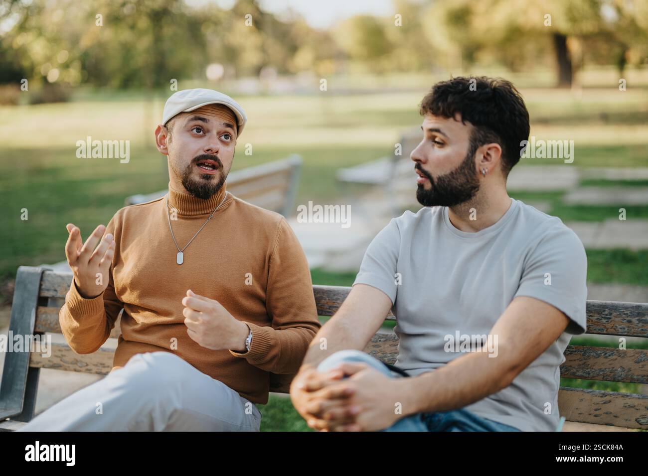 Two friends engaged in a thoughtful conversation on a park bench Stock ...