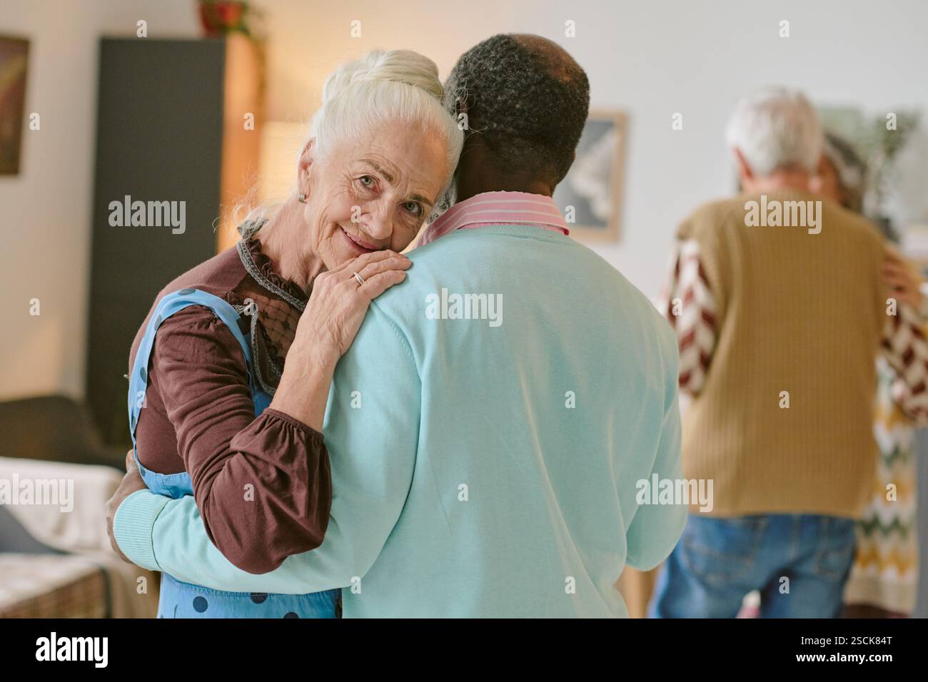 Portrait of elegant senior woman looking at camera while her ...