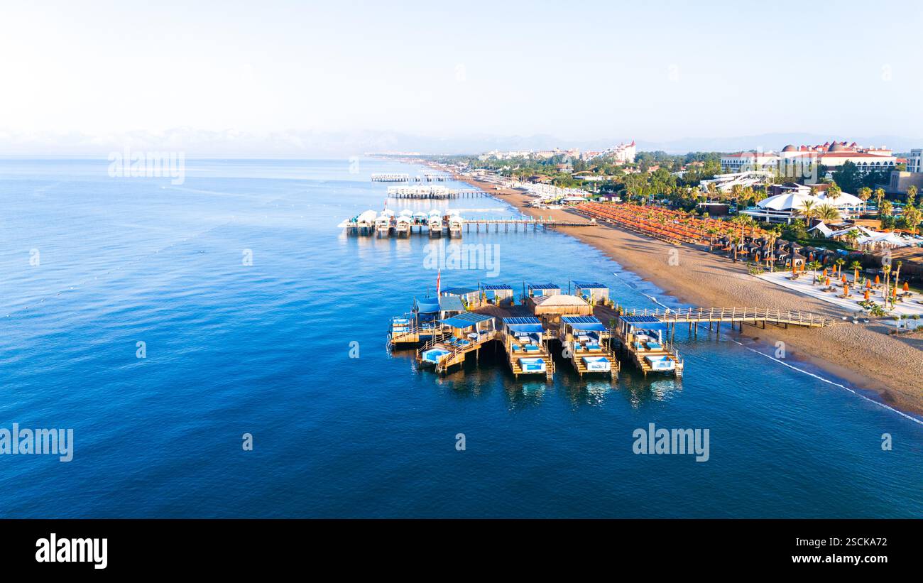 Aerial view of a luxury beachfront resort with wooden piers extending ...
