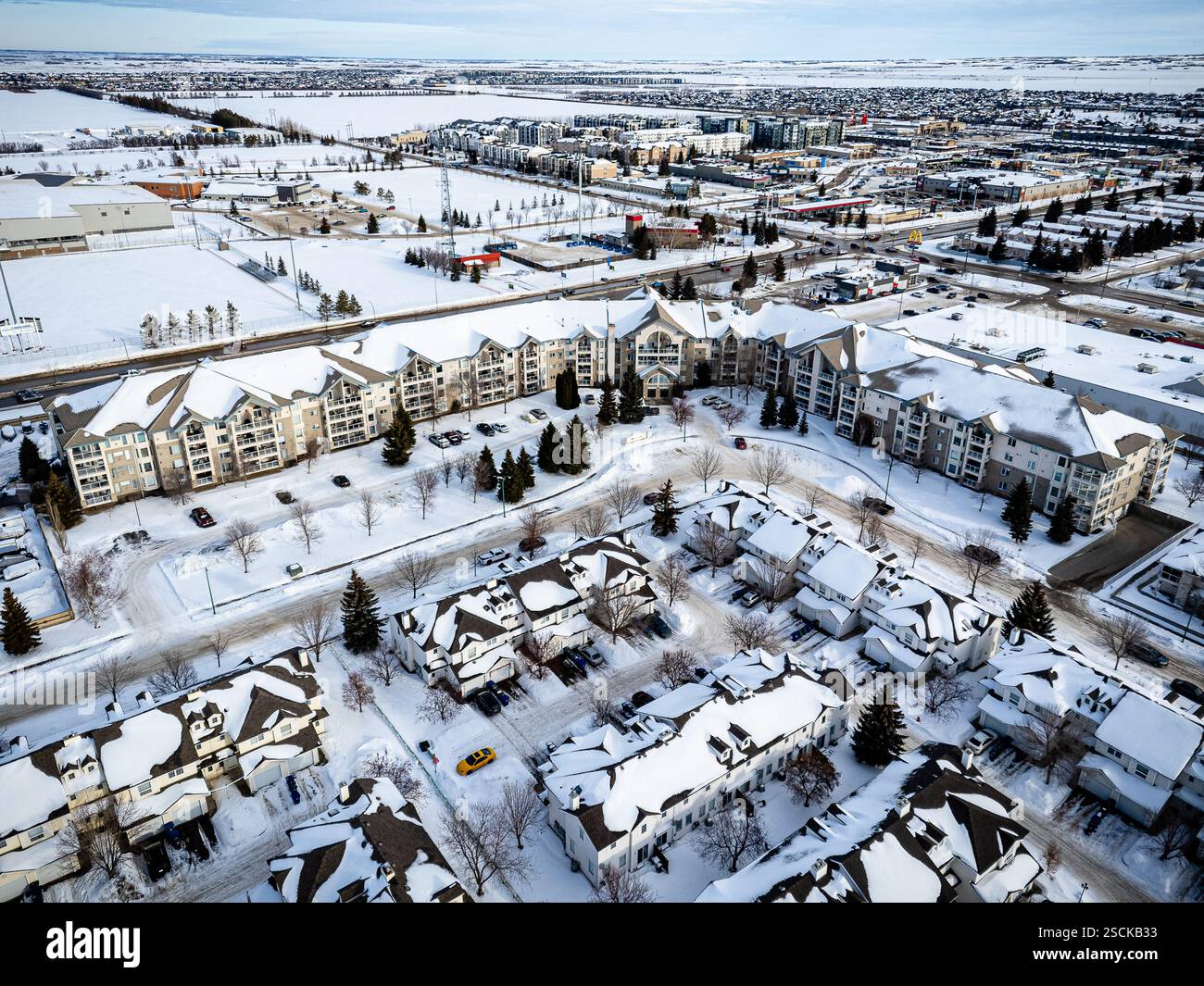 Snowy cityscape with a mix of residential and commercial buildings. The ...