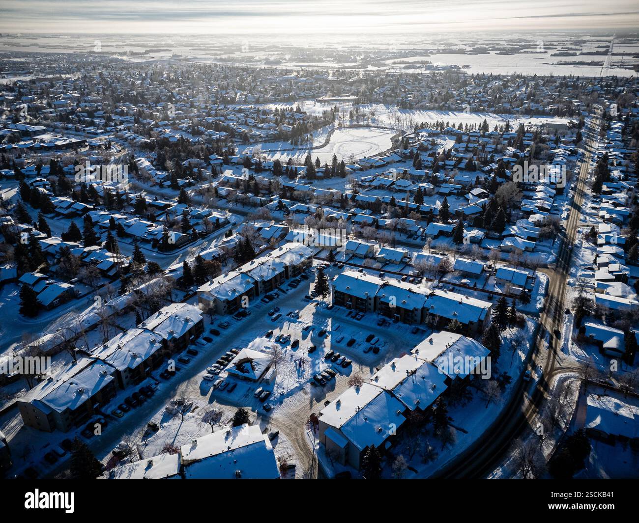 Snowy cityscape with houses and cars. The snow is covering the ground ...