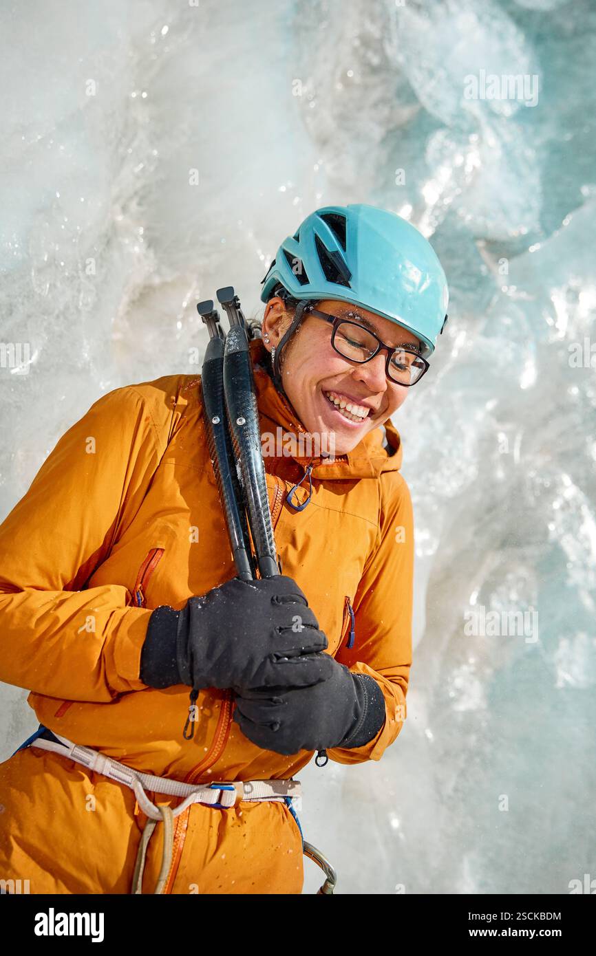 Young Asian woman Athlete in orange jacket, blue helmet and axe Ice ...