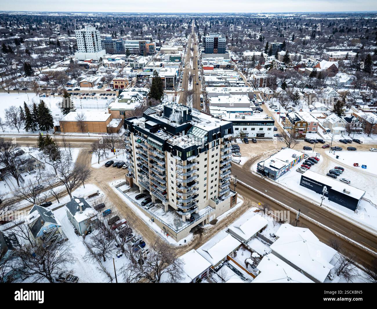 Snowy cityscape with a large apartment building in the center. Concept ...