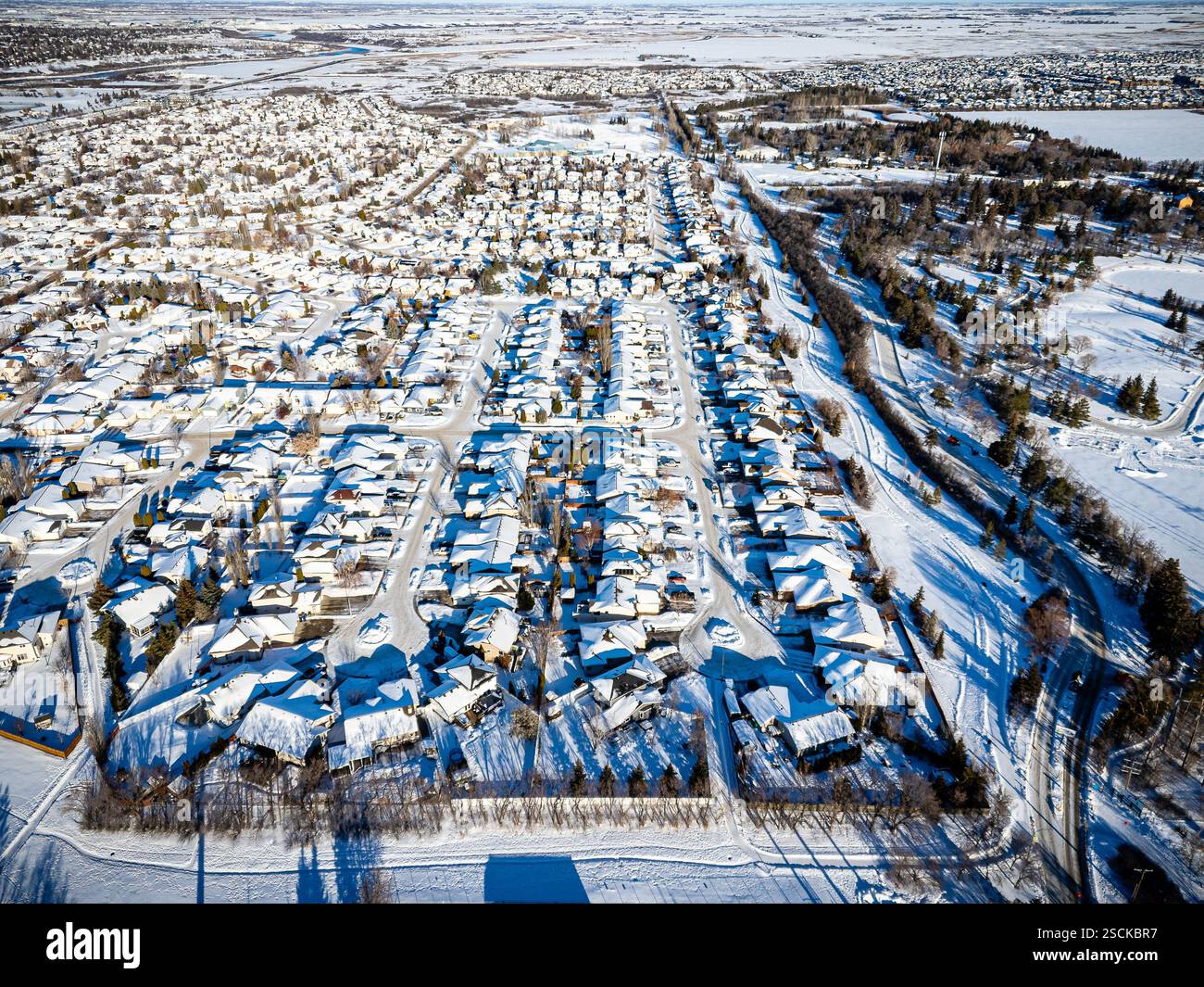 Snowy town with houses and a road. The houses are all white and the ...