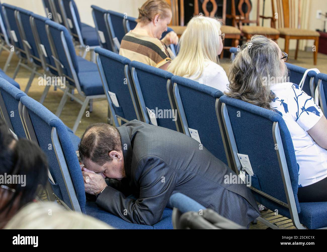 A congregant kneels in prayer at the Centro Cristiano El Pan de Vida, a ...