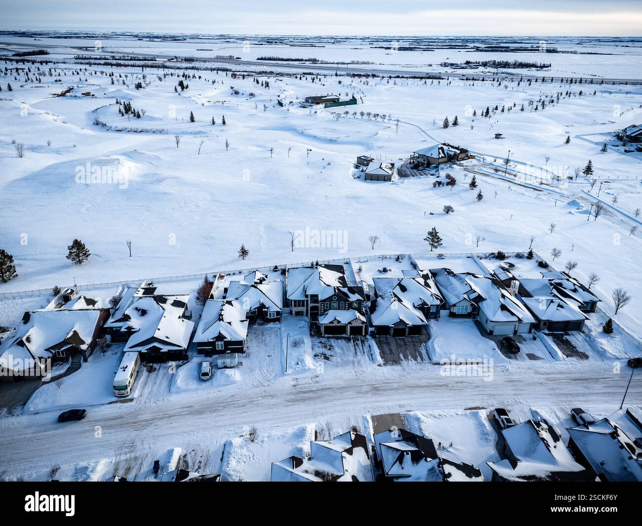 Snowy landscape with houses in the distance. The houses are covered in ...