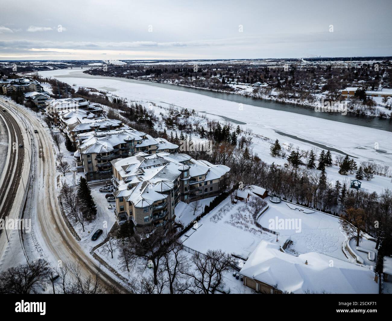 Snowy cityscape with a river running through it. The houses are all ...