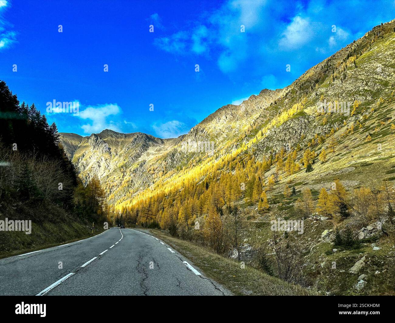 Mountain Road Under a Brilliant Blue Sky A winding road cutting through ...
