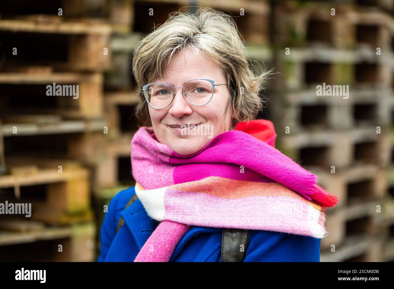 Portrait of a 38 yo white woman wearing a blue winter coat and colorful ...