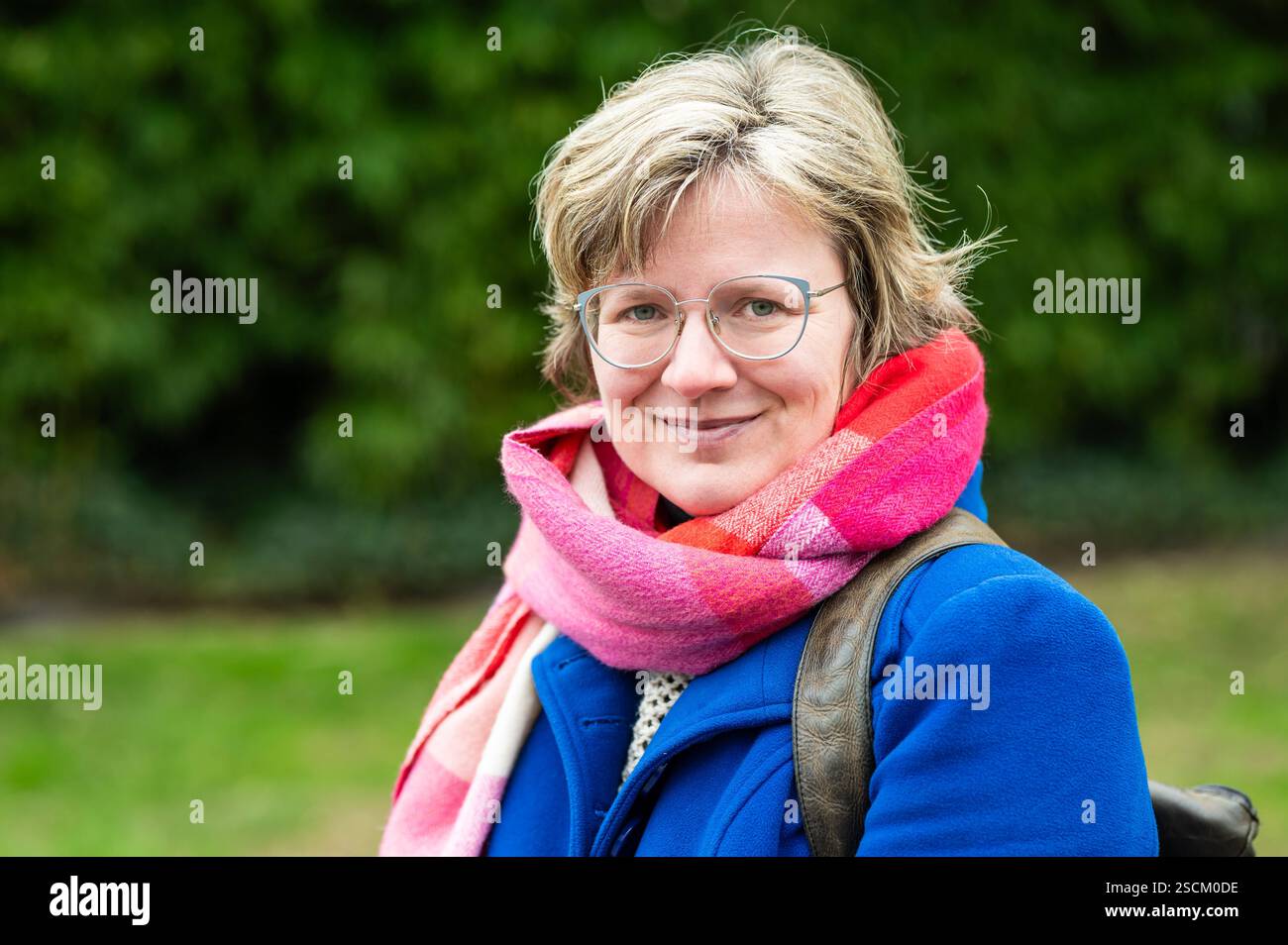 Portrait of a 38 yo white woman wearing a blue winter coat and colorful ...