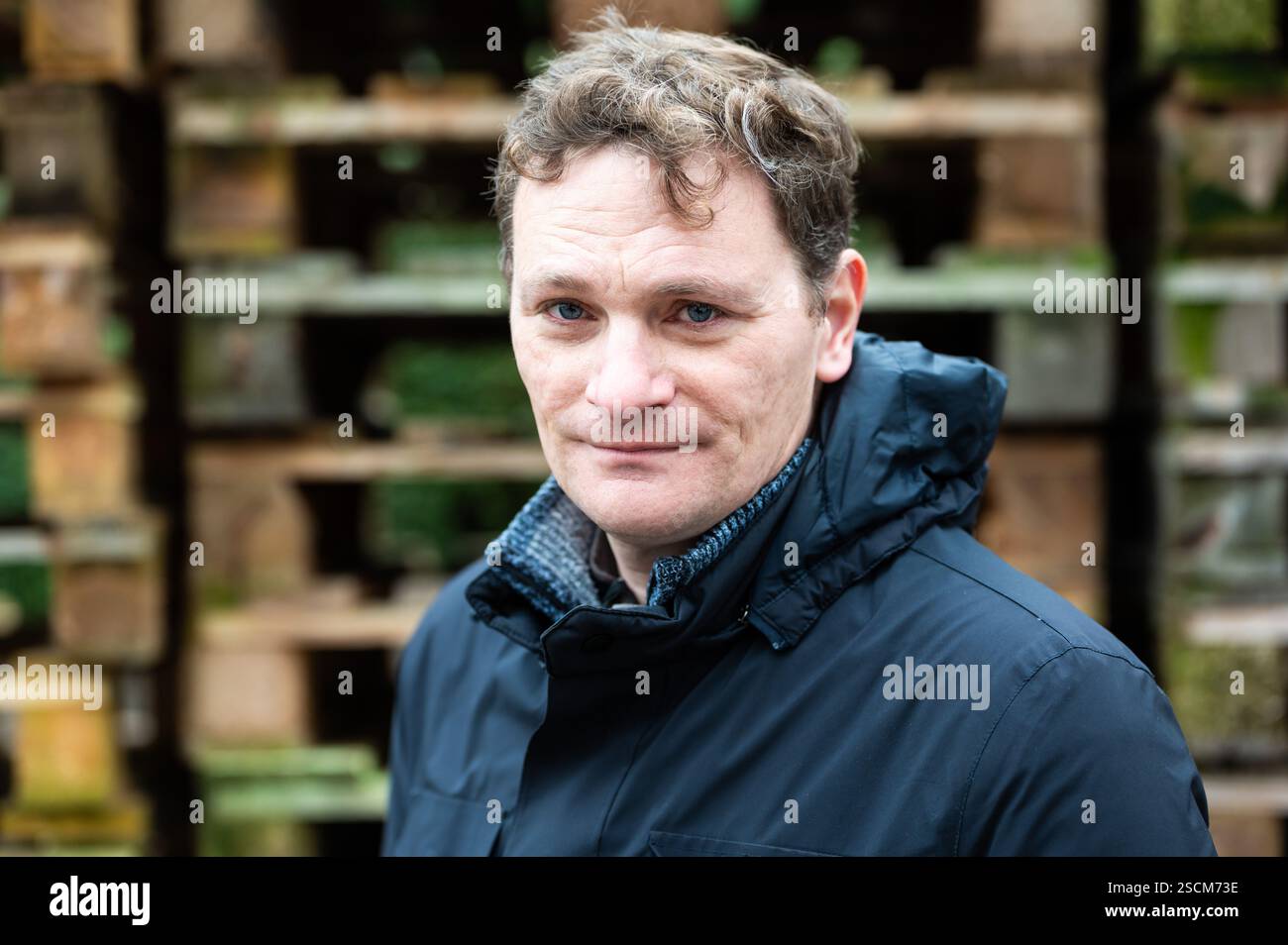 45 yo male posing in a winter jacketwith a wooden pallet background ...