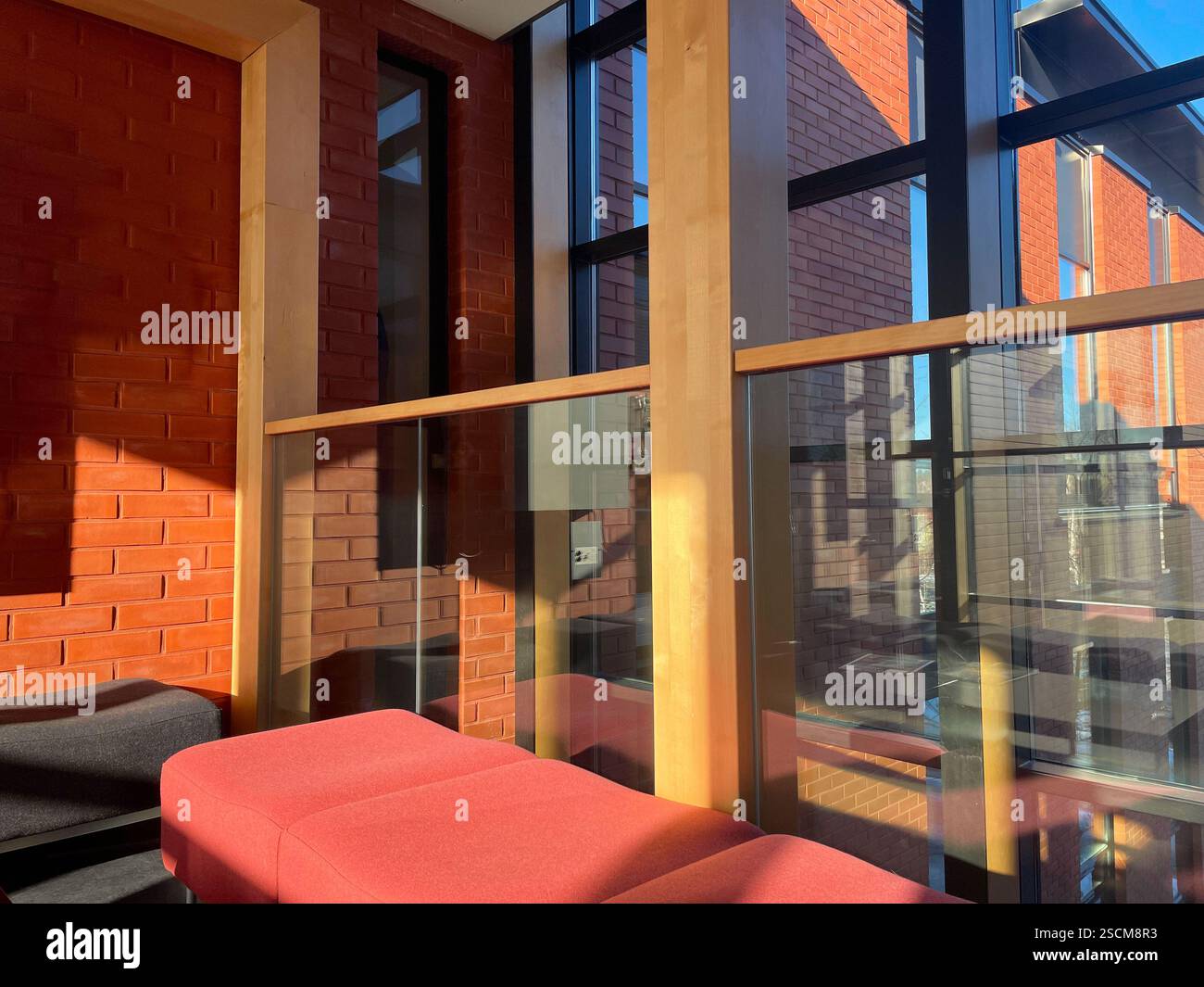 Modern office waiting room with red brick wall and big glass window ...