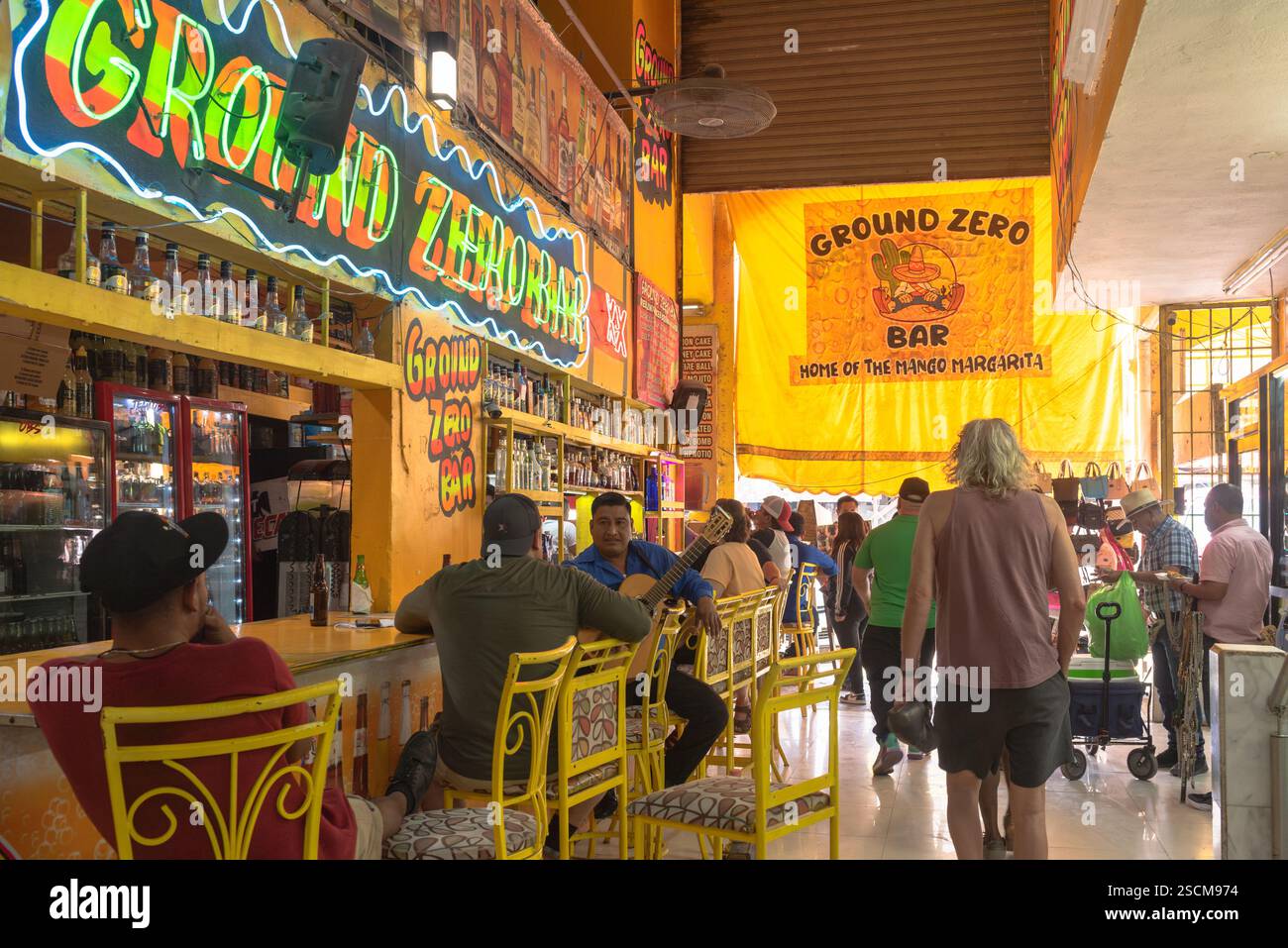 Men sitting at bright yellow Ground Zero Bar, Home of the Mango ...