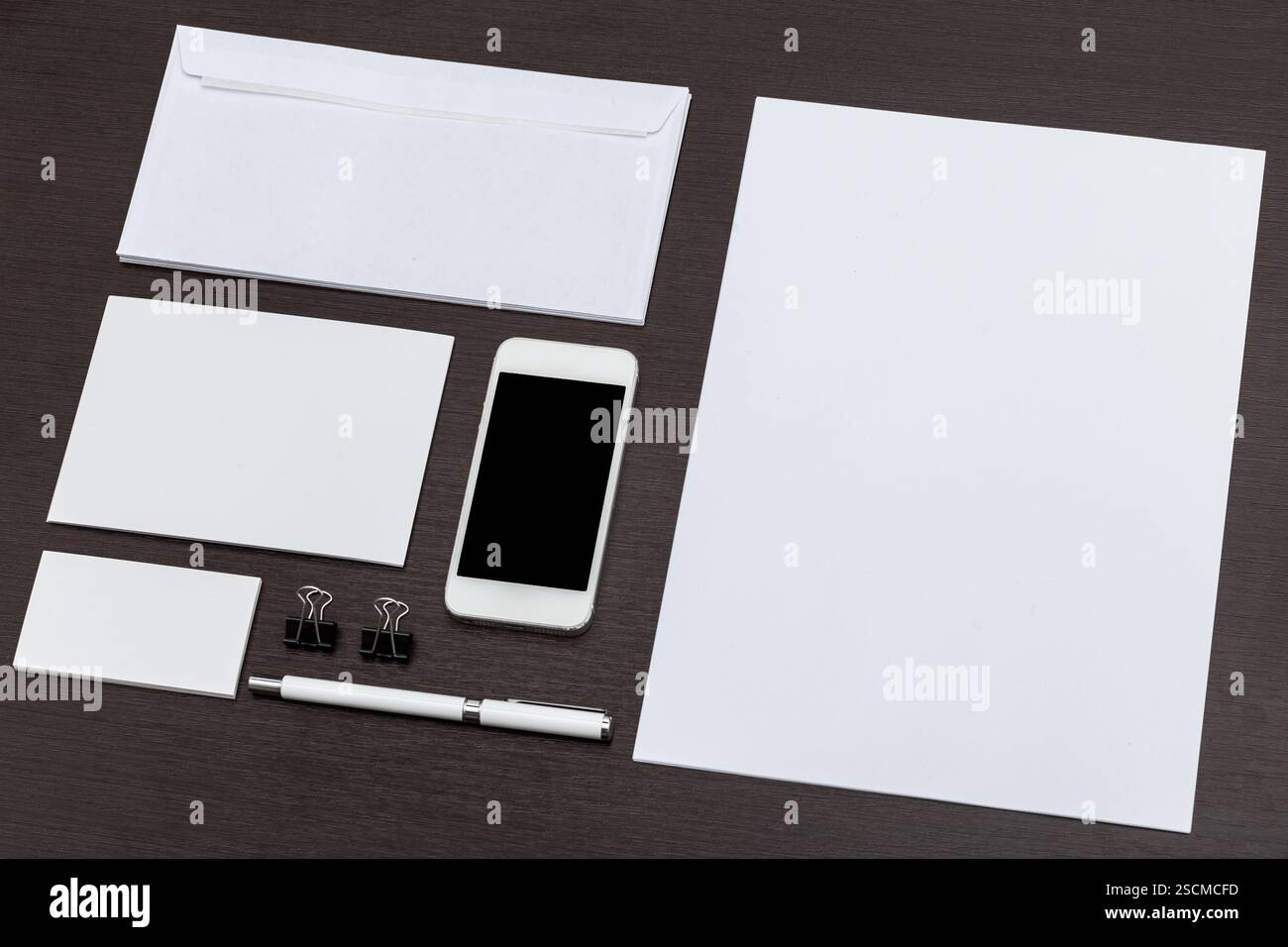 Collection of stationary items on a dark wooden table arranged for an ...
