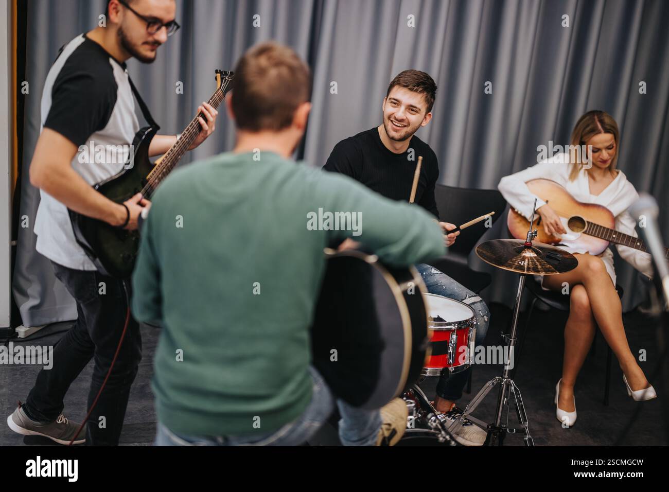 Group of musicians rehearsing together with instruments in a studio ...