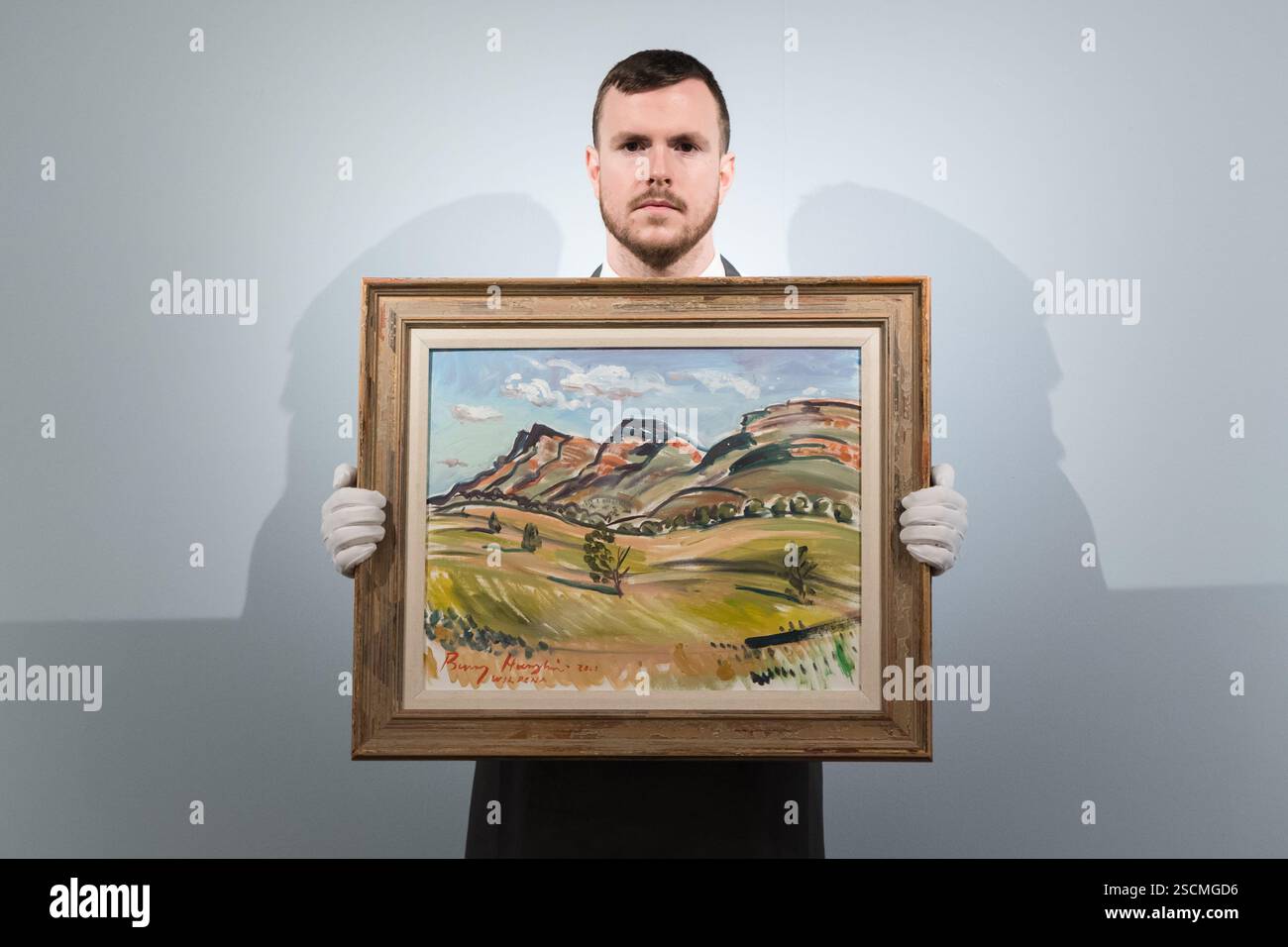 London, UK. 7th February, 2025. An art handler holds a painting titled ...